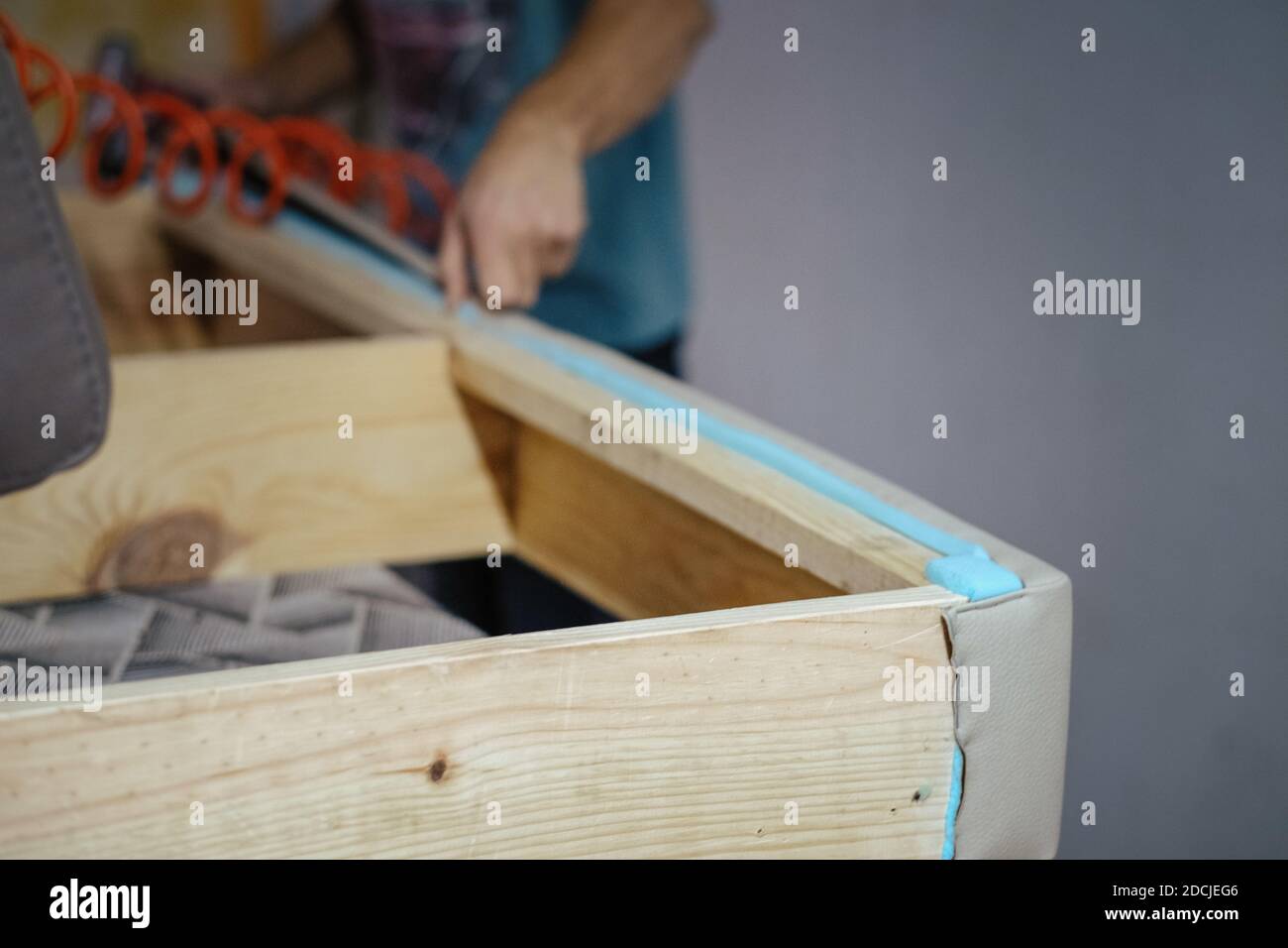 A closeup shot of a carpenter using an industrial stapler on wooden ...