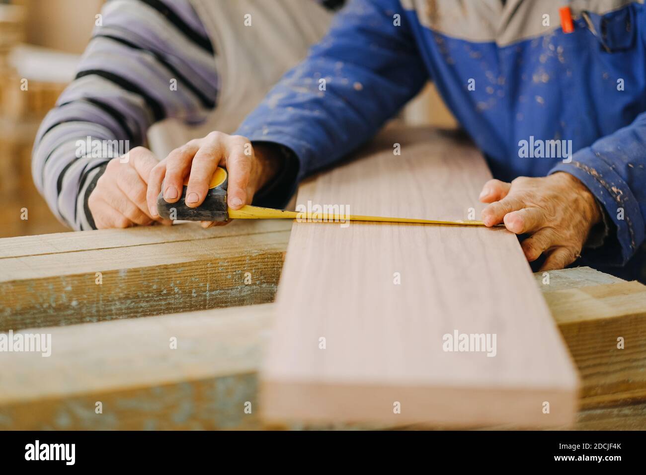 A closeup shot of a carpenter measuring on a piece of plywood Stock ...