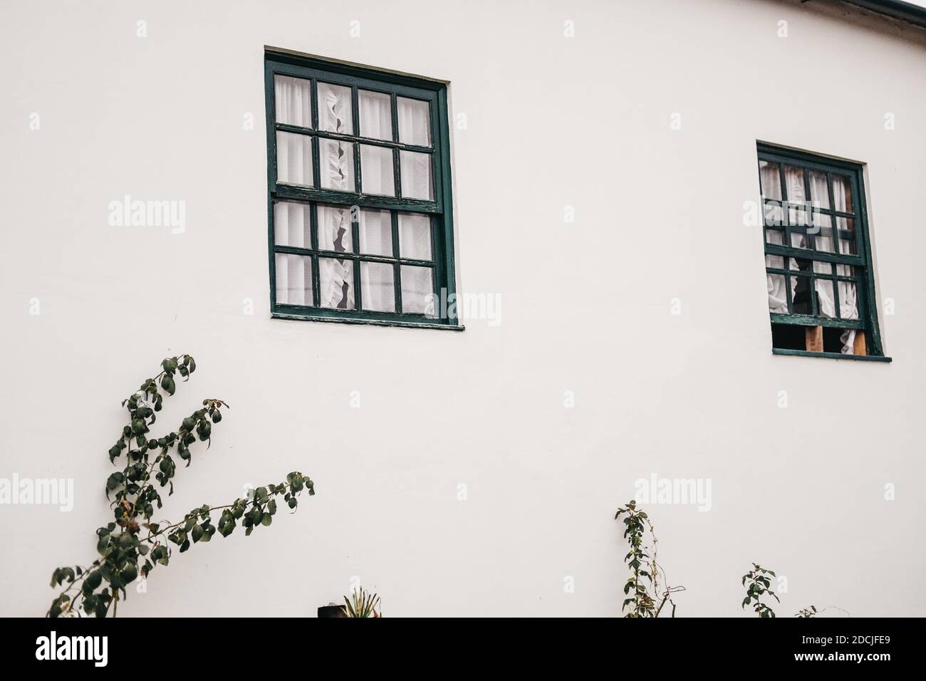 A white house exterior with caged vintage windows Stock Photo - Alamy