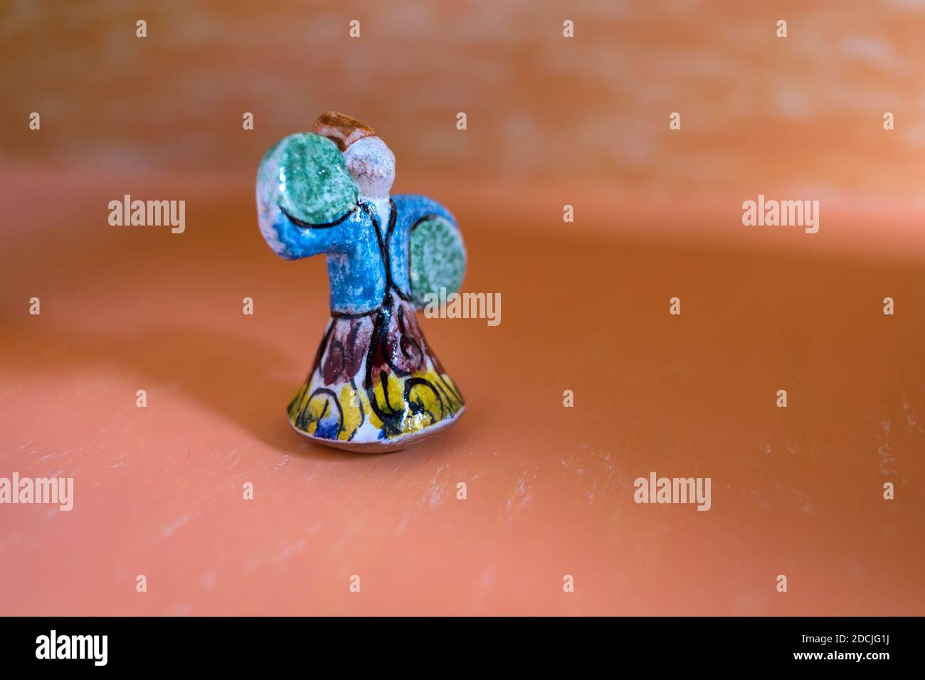colored pottery doll of dancing dervish on orange background for wall ...
