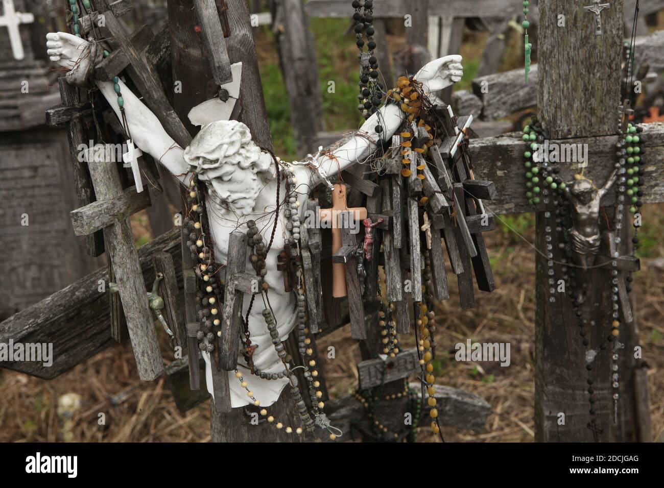 Broken figure of Jesus Christ decorated with small wooden crosses on ...