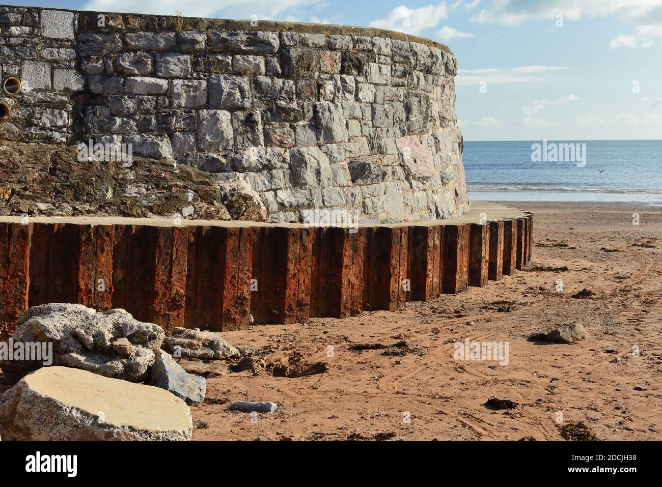 A curved section of seawall with extended concrete foundations Stock ...