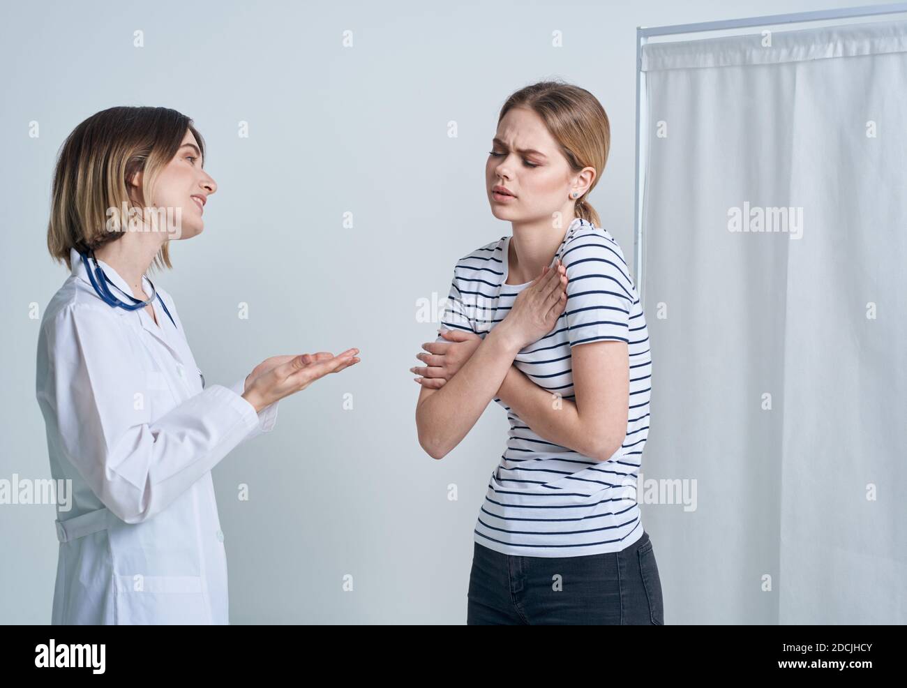 woman tells the doctor her health problems on a light background Stock ...