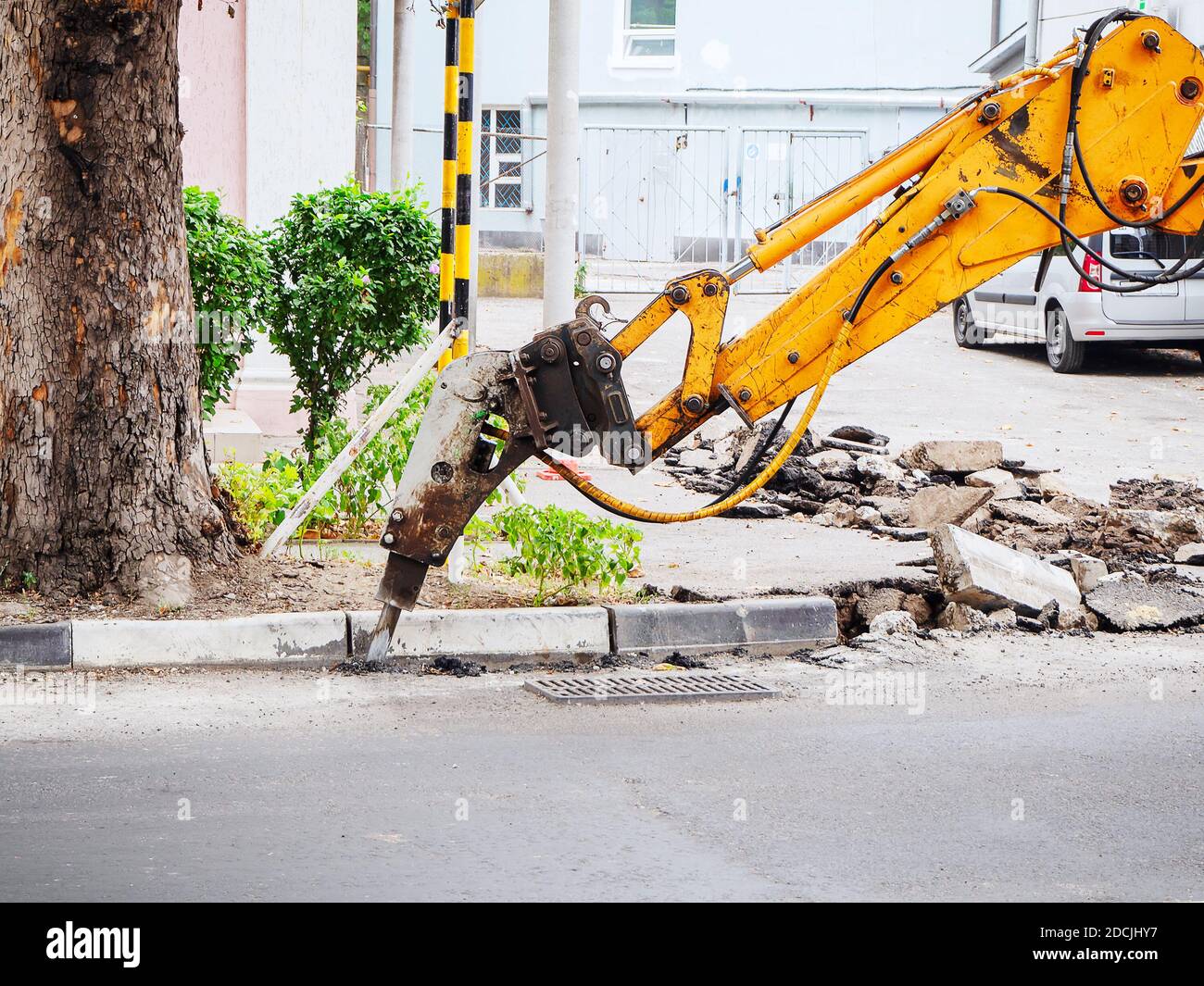 Hydraulic hammer crushing asphalt along the road in the street Stock ...