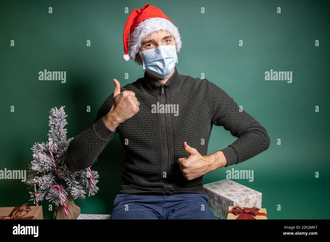 man with many wrapped gifts on green background Stock Photo - Alamy