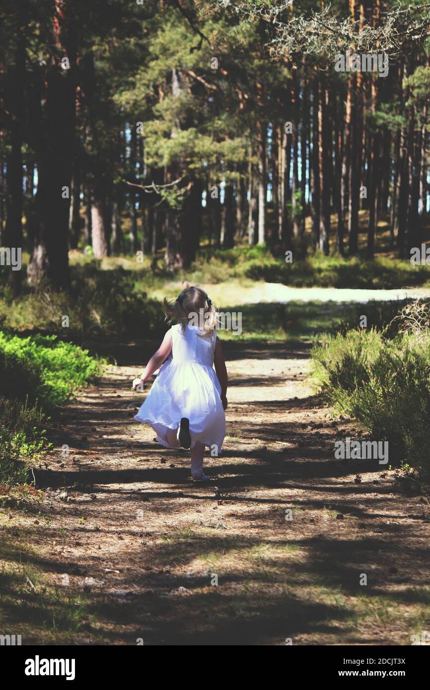 Little girl running in sunlight in the autumn park Stock Photo - Alamy