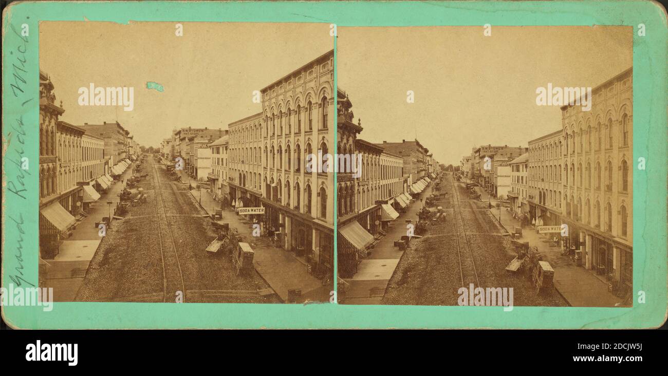 Street scene with buildings, trolley tracks, store fronts, and ...
