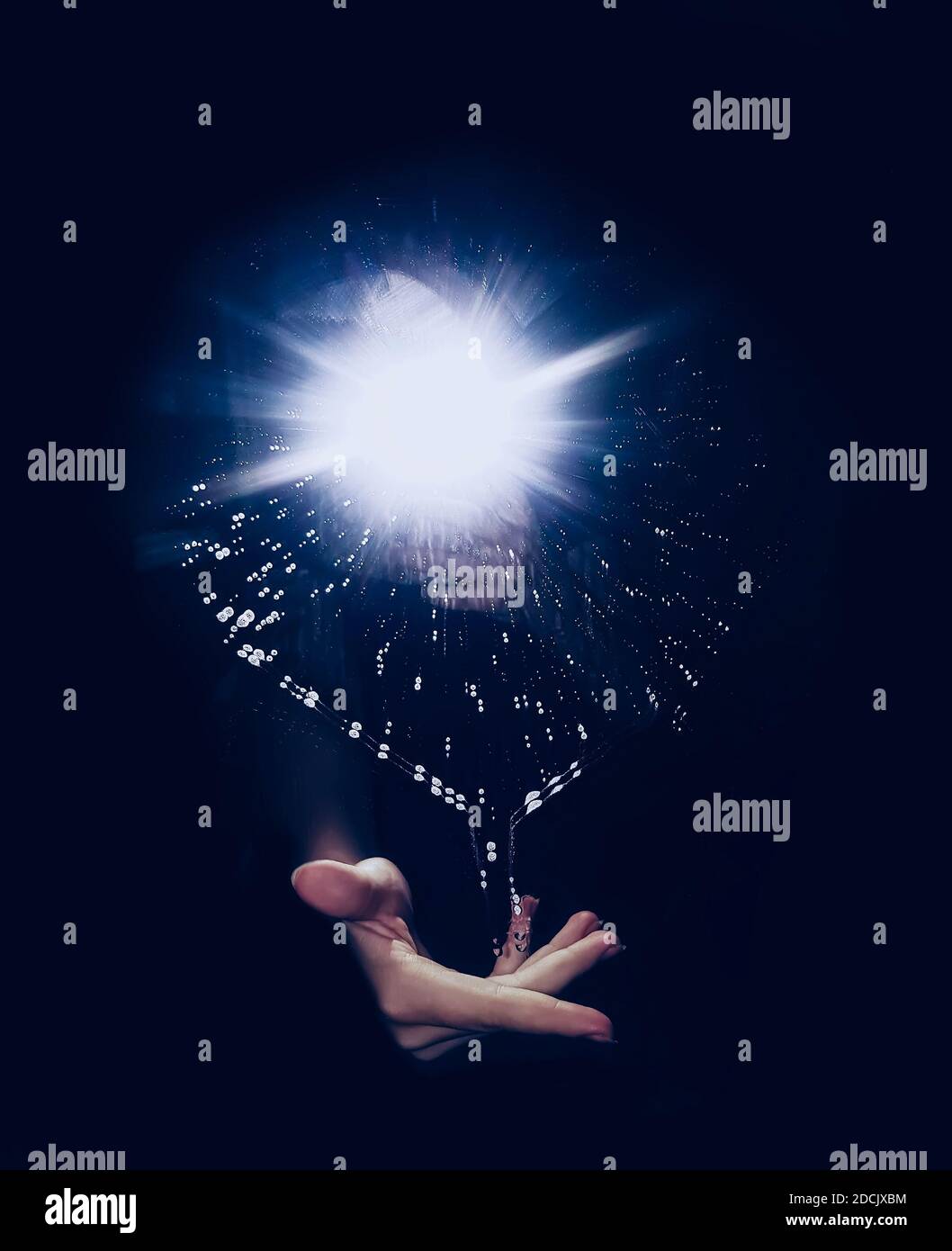 Brighjt flare of light above the nand. Magical flash on dark background ...