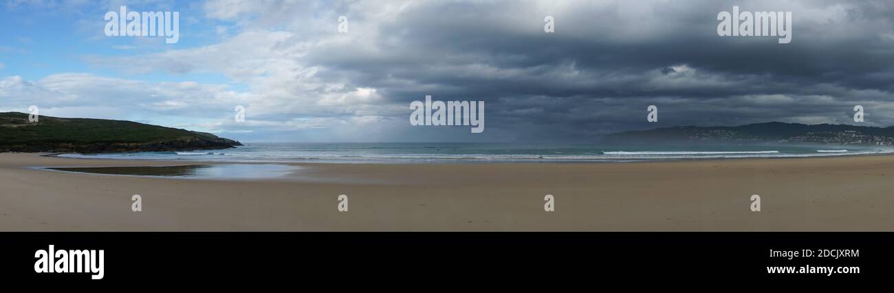 A panorama of an empty and large beautiful golden sand beach underneath ...