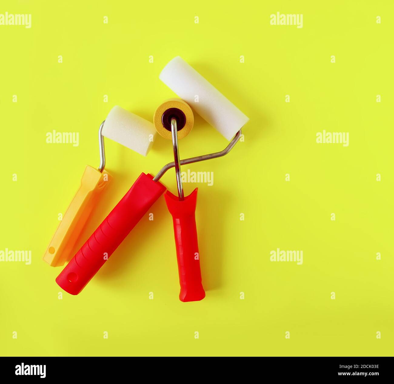 Home repair tools on bright yellow background. Two foam rollers for ...