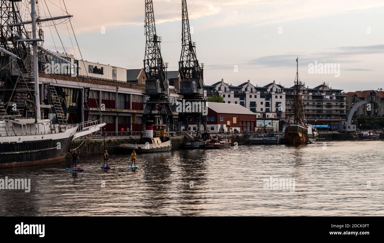 Three people paddleboard outside M Shed on Bristol's Floating Harbour ...
