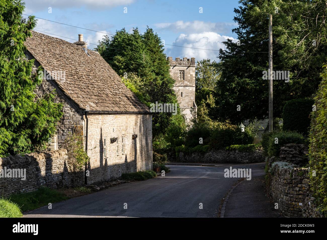 Sun shines on the traditional stone cottages and church tower of ...