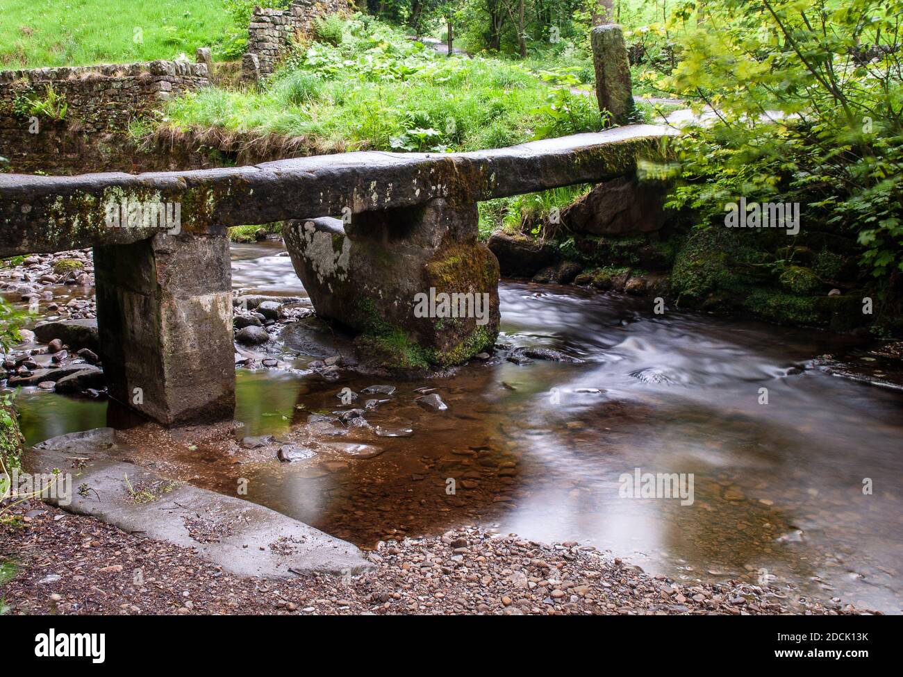 A traditional stone clapper bridge crosses the Wycoller Beck stream at ...