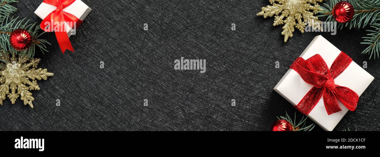 White gift boxes with red ribbon bow and golden snowflakes on black ...