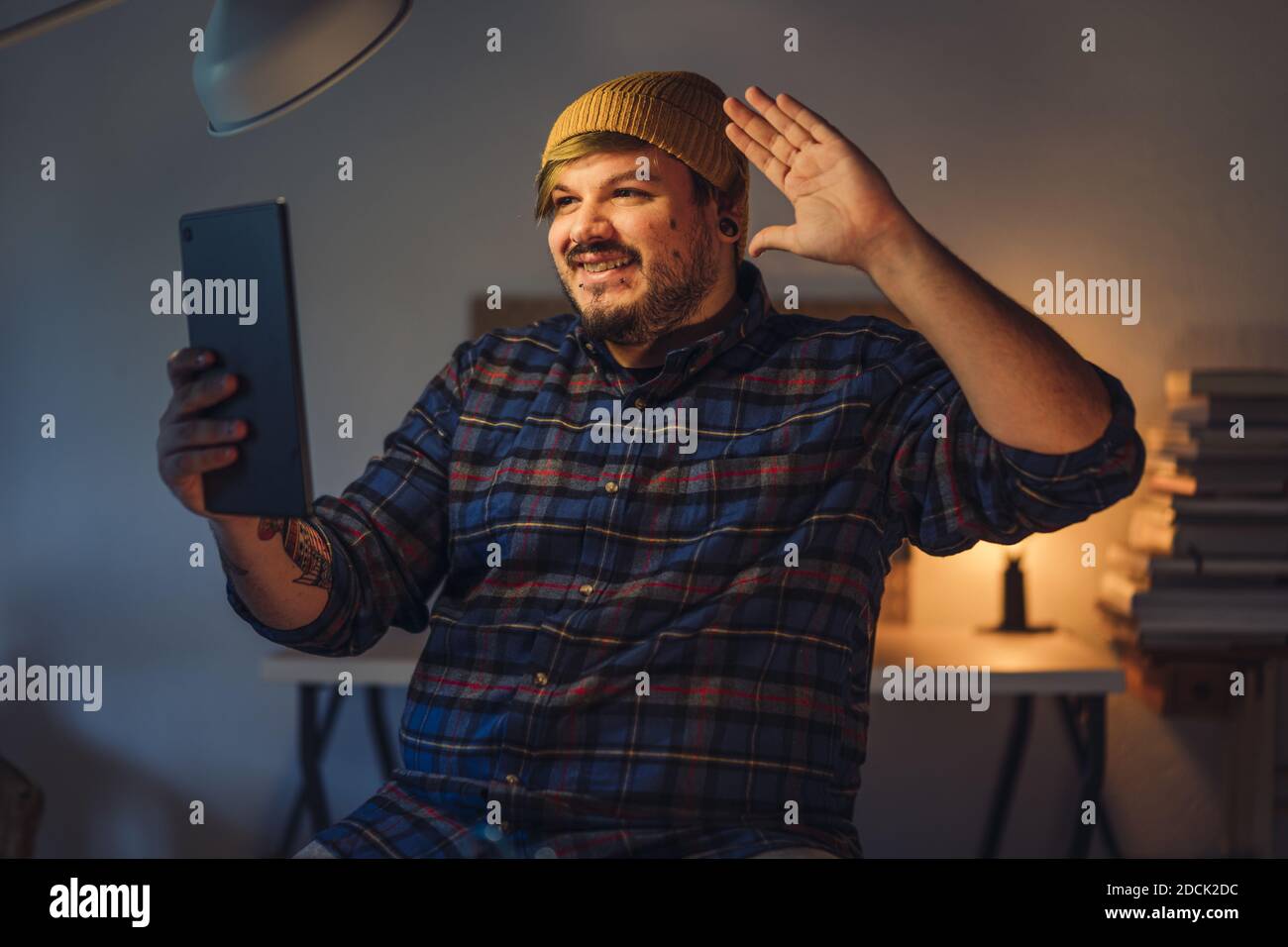 A closeup portrait of a smiling cute man with hat making video call on ...