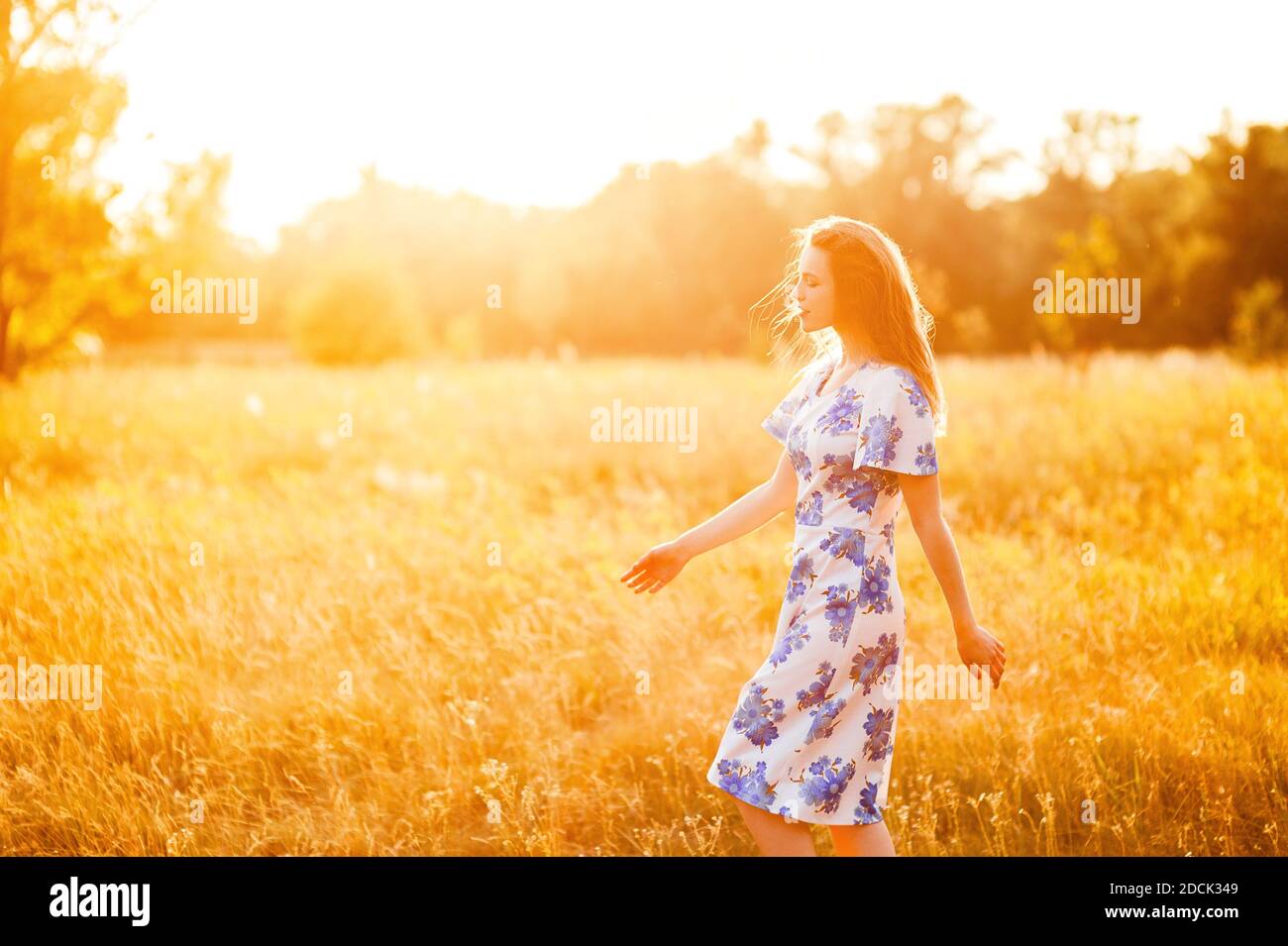Beautiful Tender lovely young woman walking in flower park in dress at ...