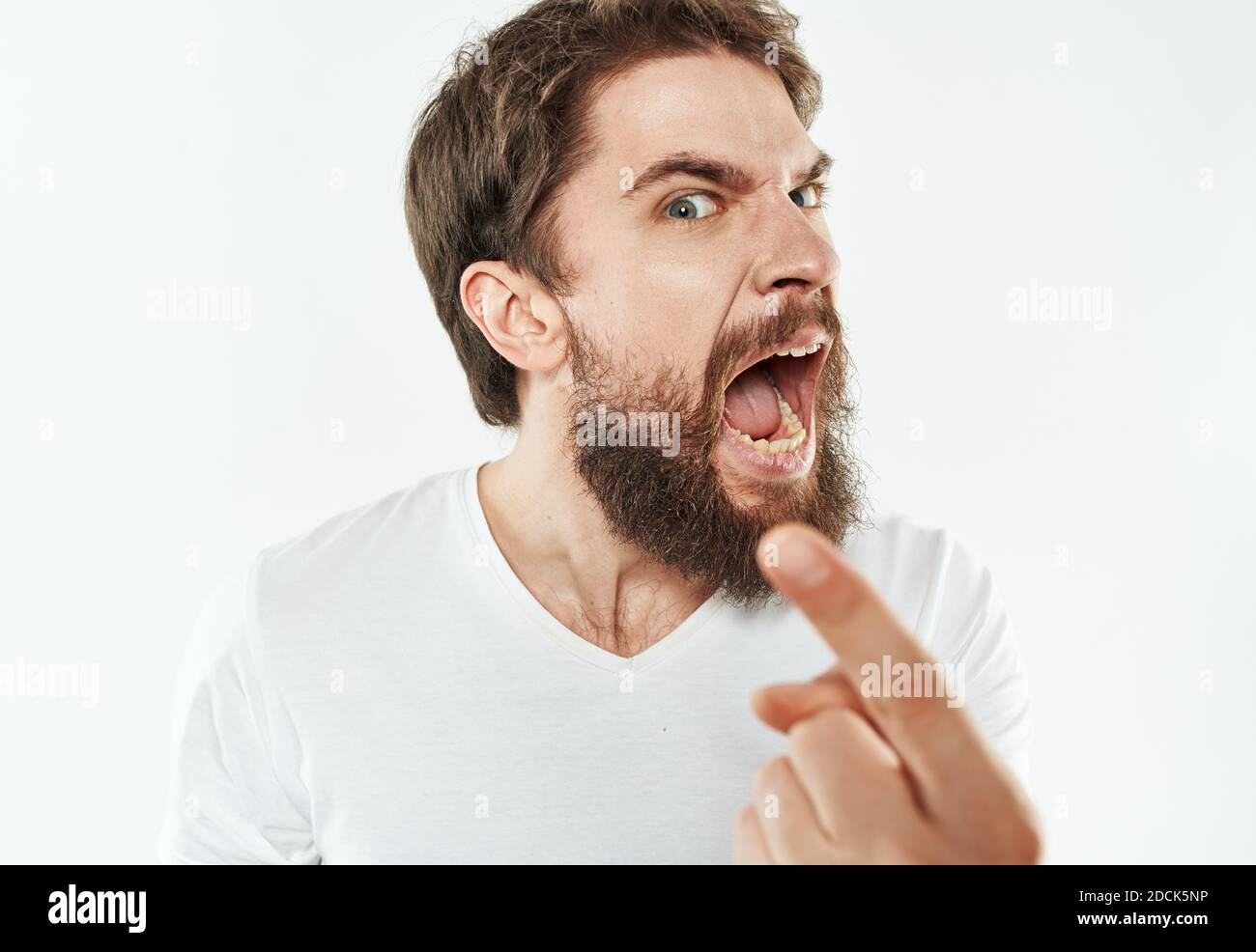 Angry man in a white t-shirt shows a fist gesturing with his hands to ...