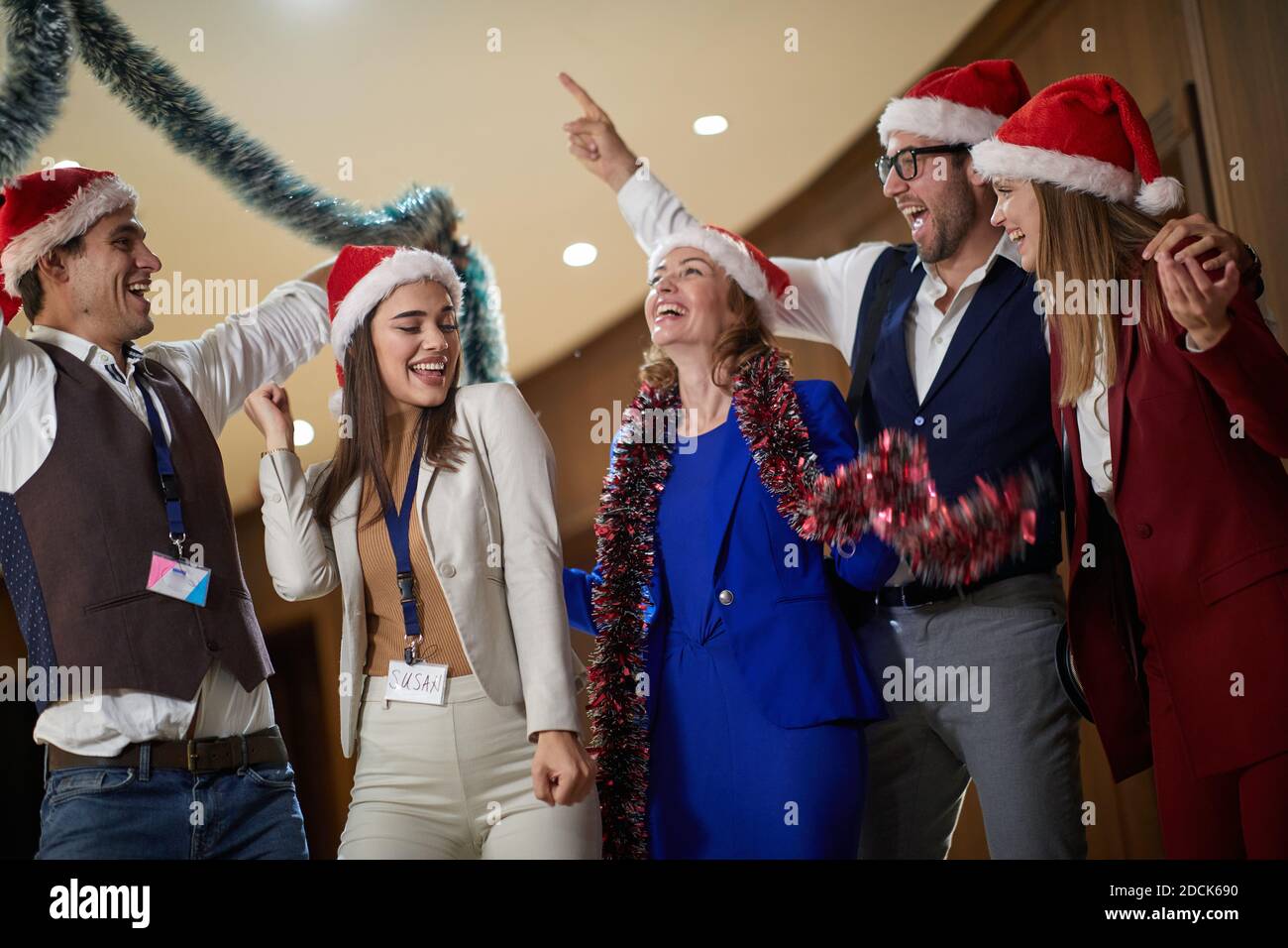A group of excited colleagues making a holiday atmosphere at workplace ...