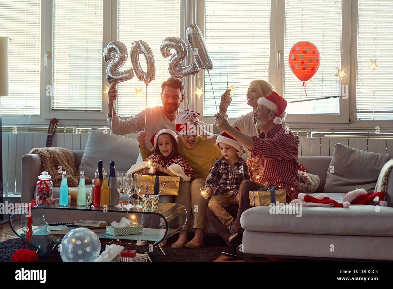 Happy family enjoying New Year eve in home festive atmosphere together ...