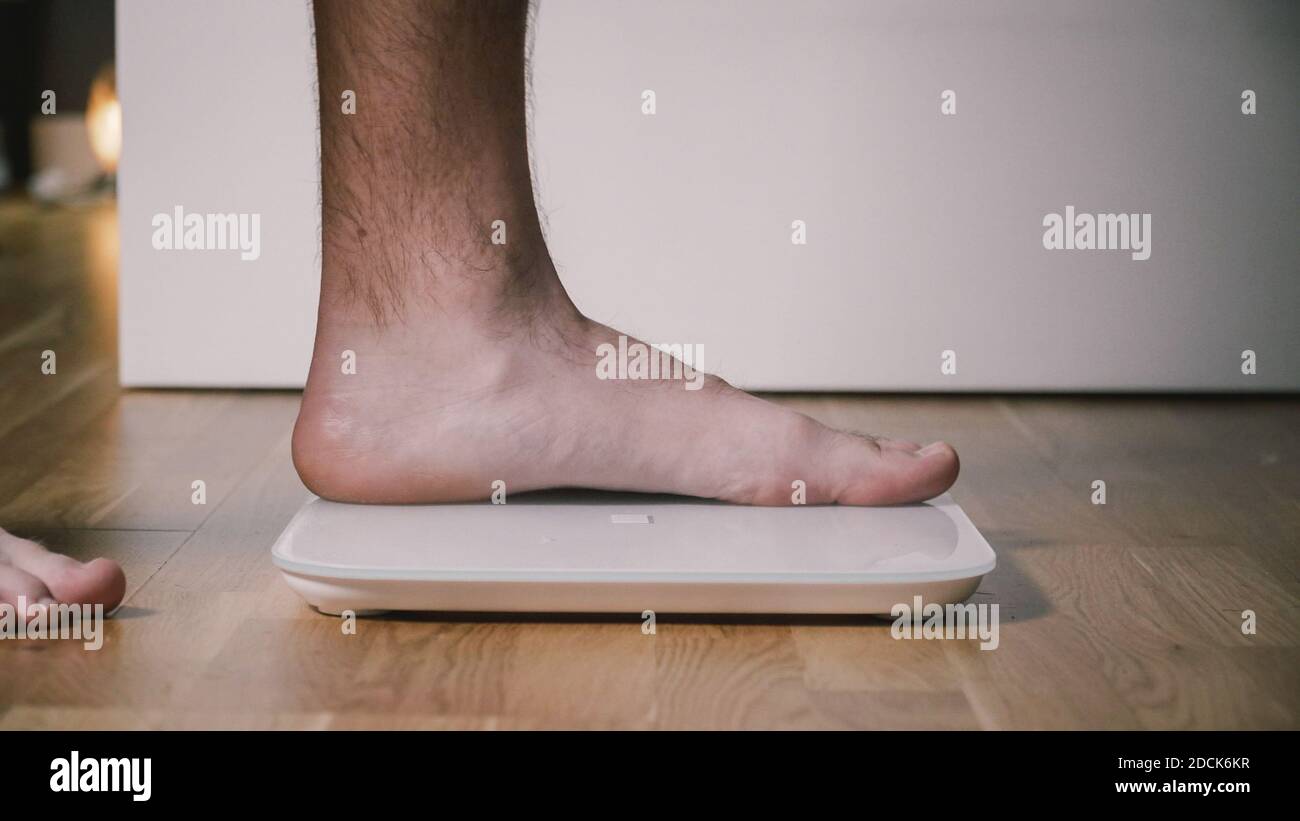 Man step on digital glass scales to check weight. Male weighting on ...