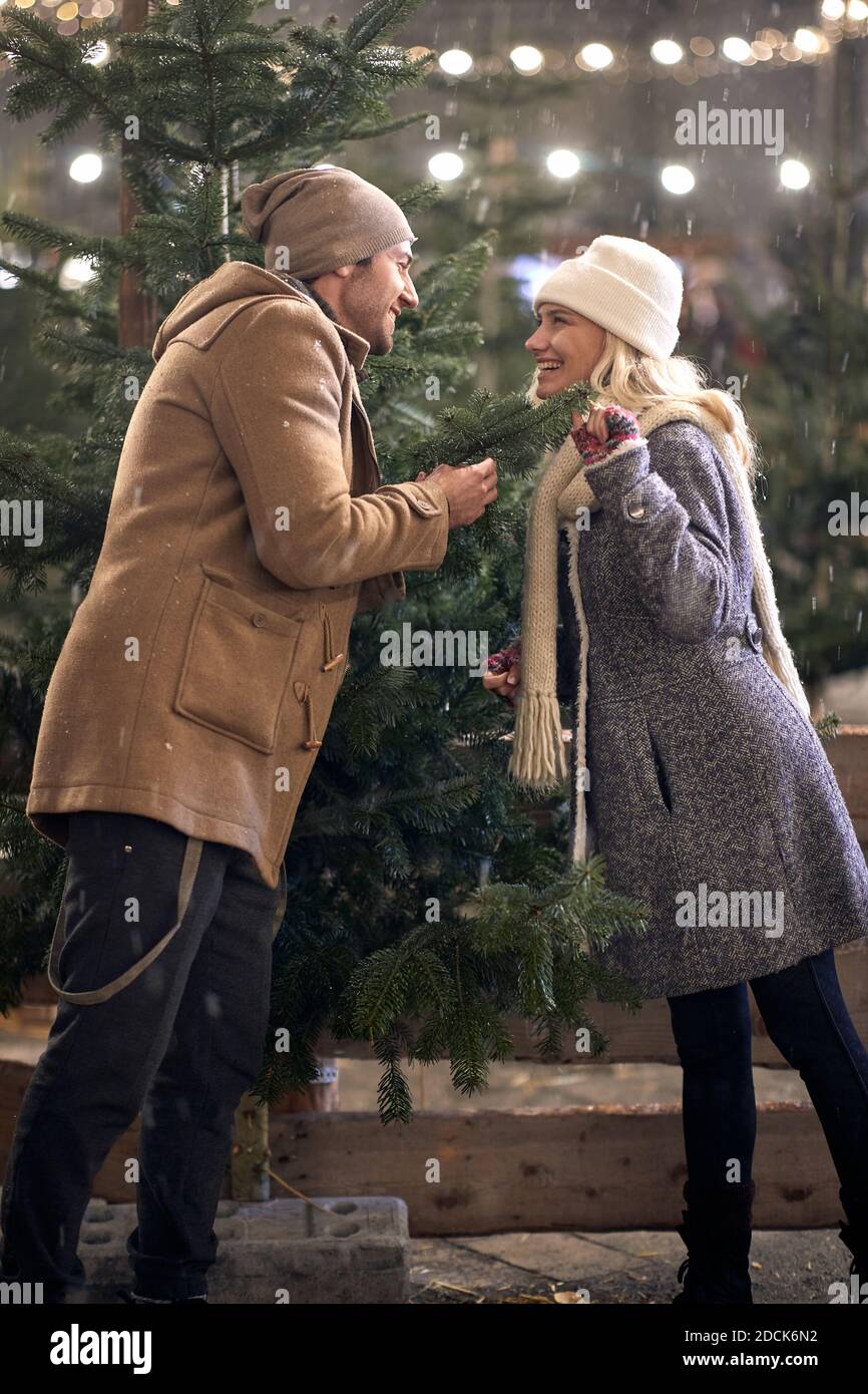 A young lovely couple in romantic moments around christmas tree in a ...