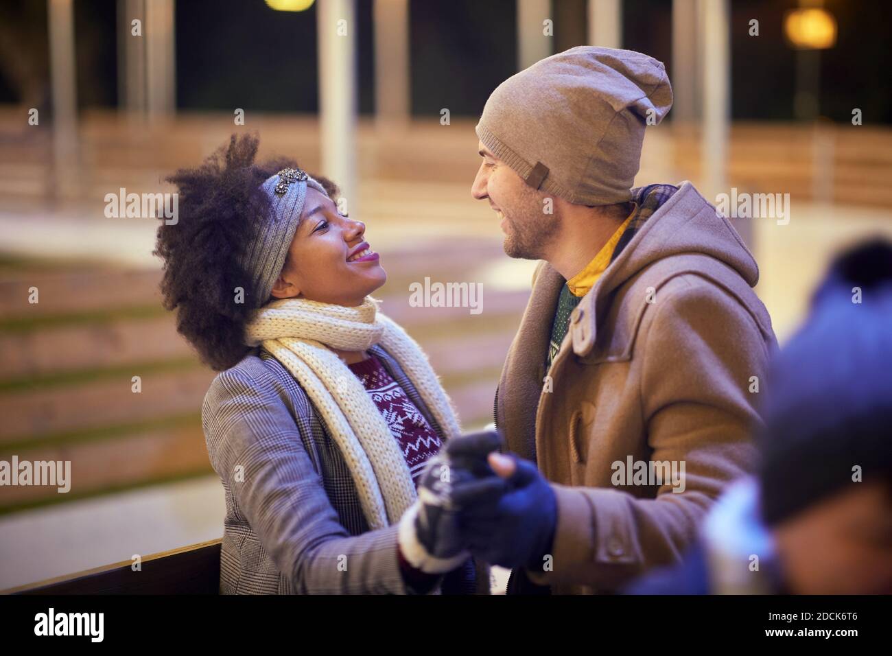 A young couple in love dancing at ice rink on a beautiful night ...