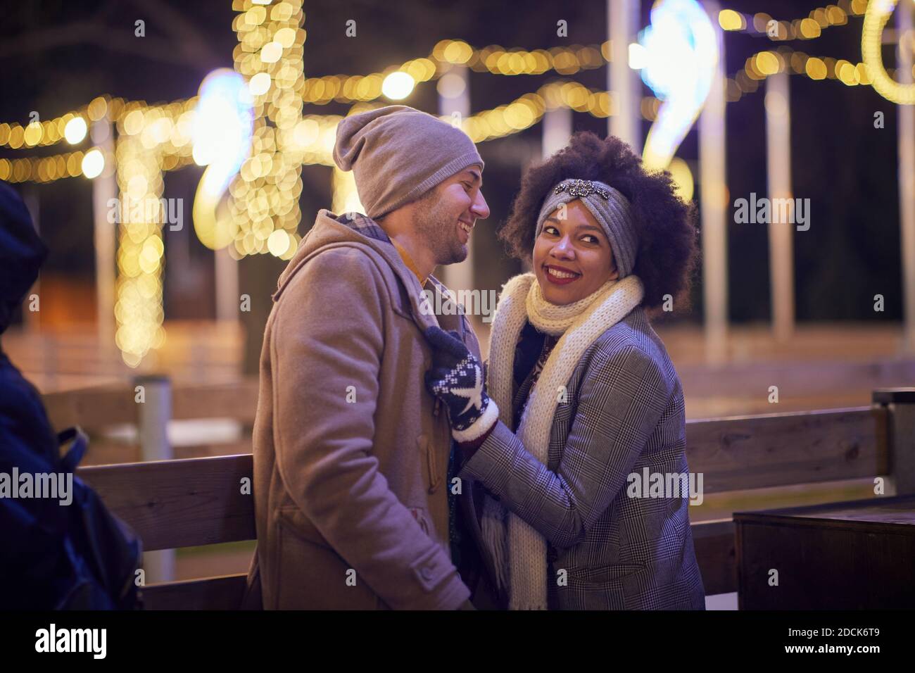 A young couple in love enjoying at ice rink on a beautiful night ...