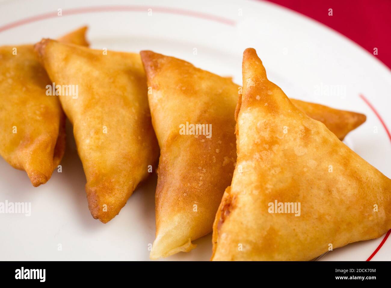Chinese triangle pies on white plate. Fried food, restaurant menu ...