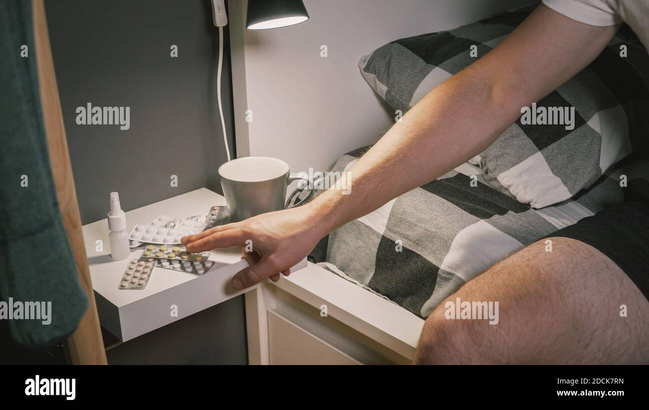 Sick man taking medicine in bedroom. Male take pill in bed. Caucasian ...