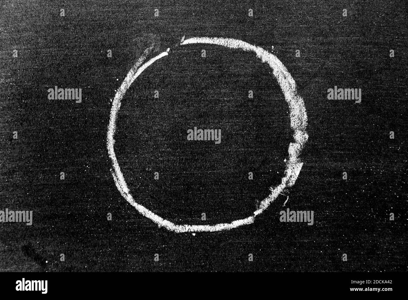 White color chalk hand drawing in circle or oval shape on black board ...