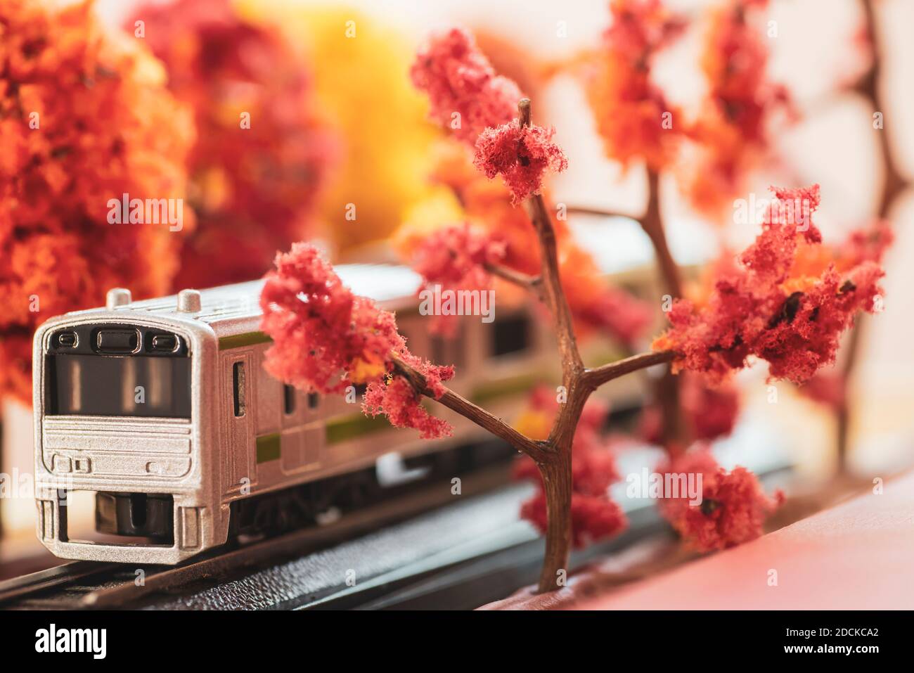 Miniature train toy at a train platform in autumn or fall season ...