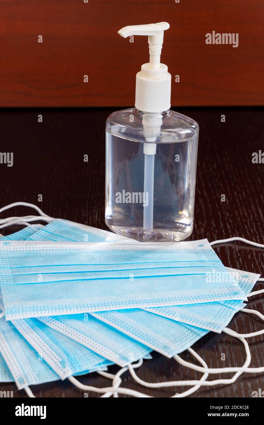 a bottle of hand sanitizer and disposable face masks. These items can ...