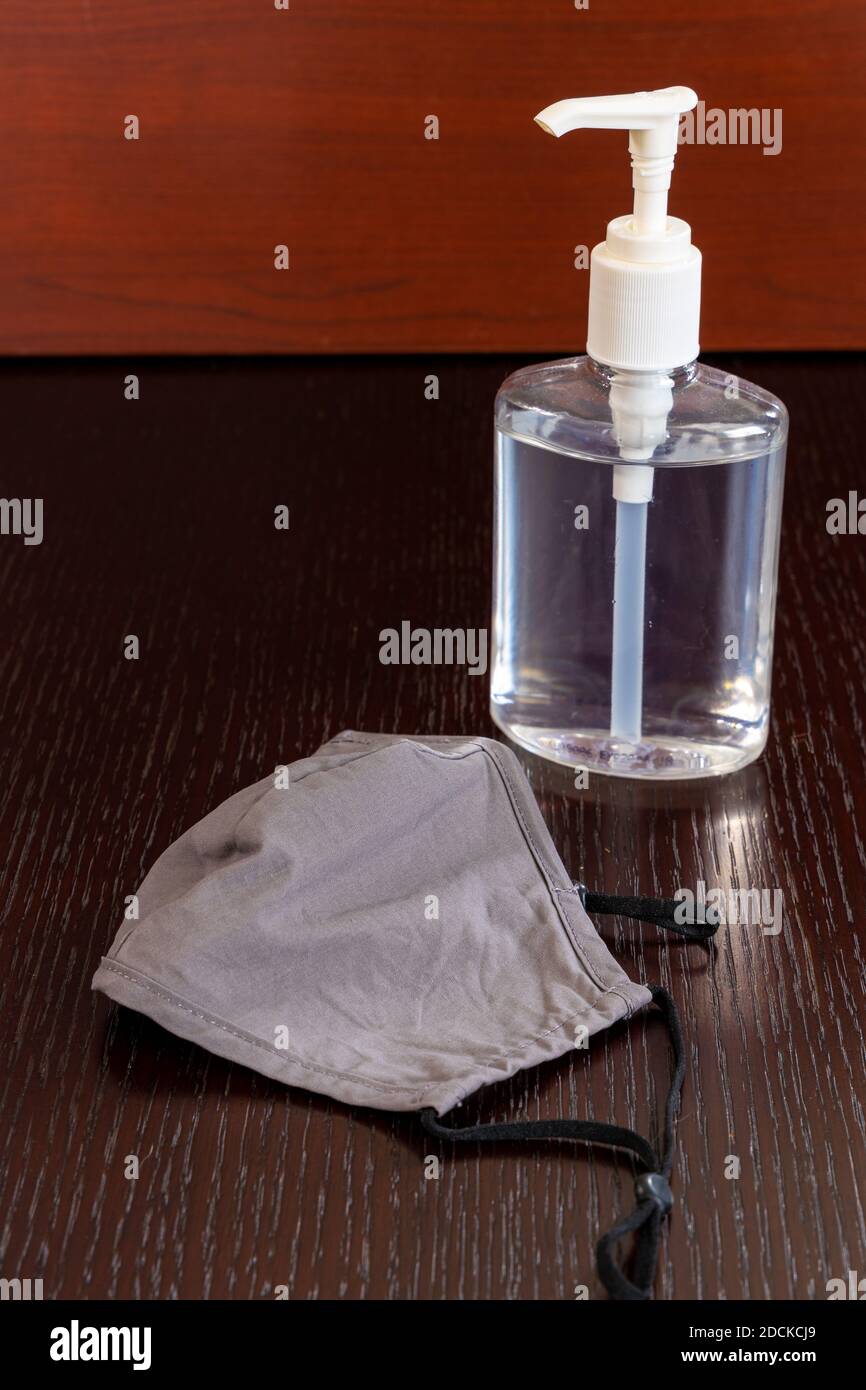 a bottle of hand sanitizer and a reusable face mask. These items can ...