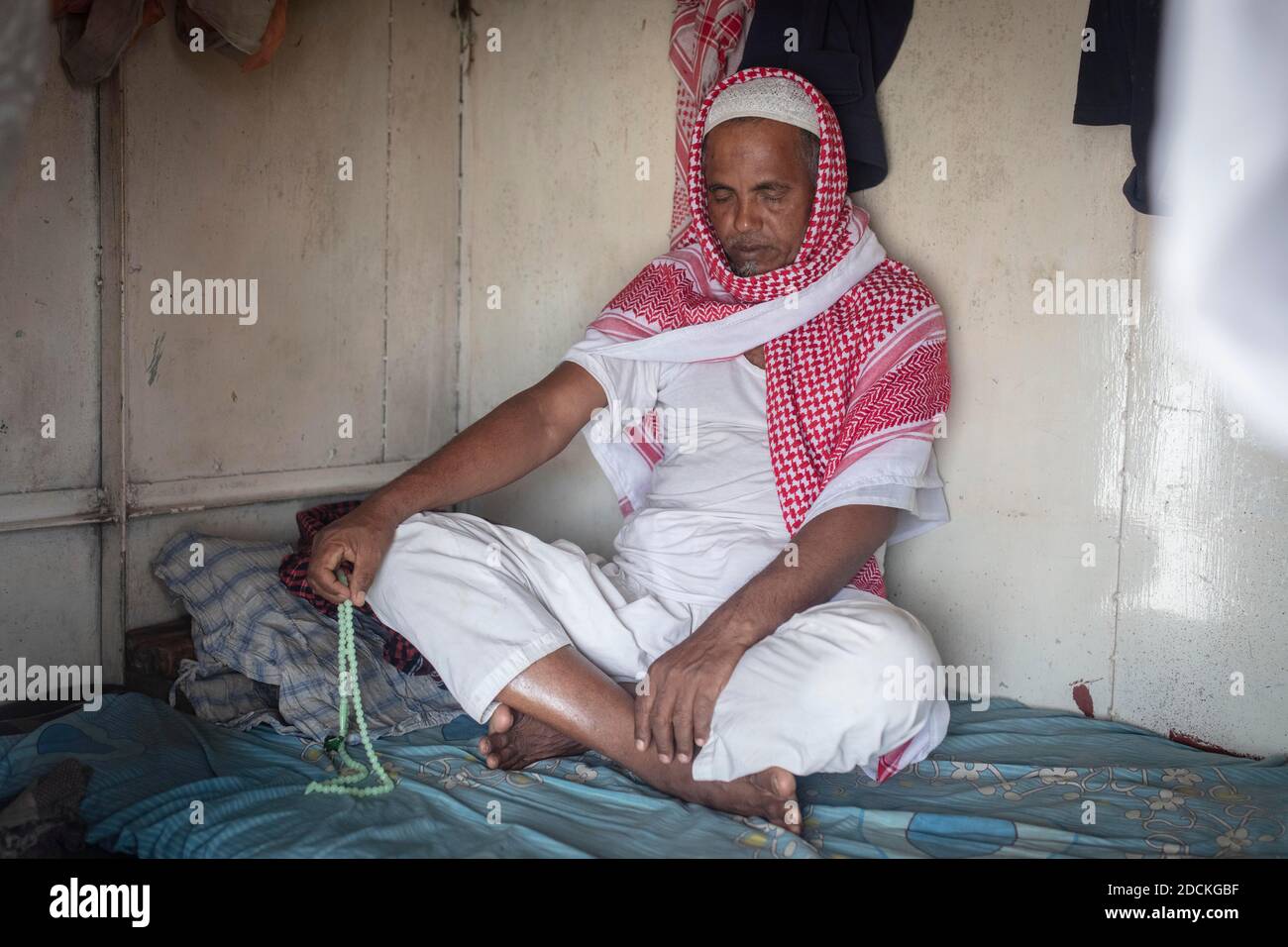 Sailor praying in his sleeping cabin on a freighter in the port of ...