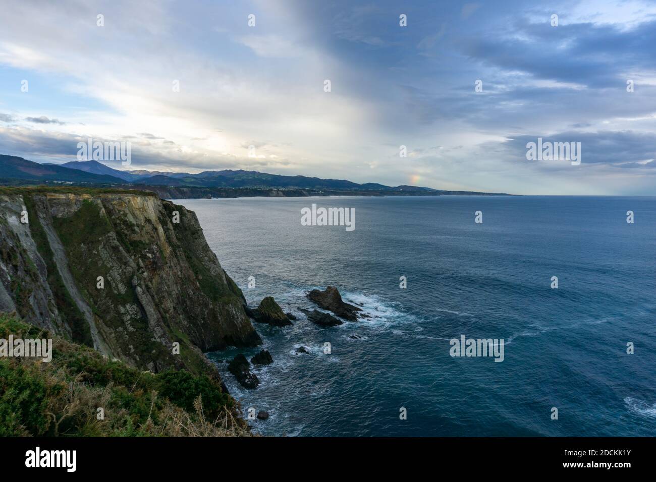 View of jagged and rocky ocean coast with cliffs and a rainbow Stock ...