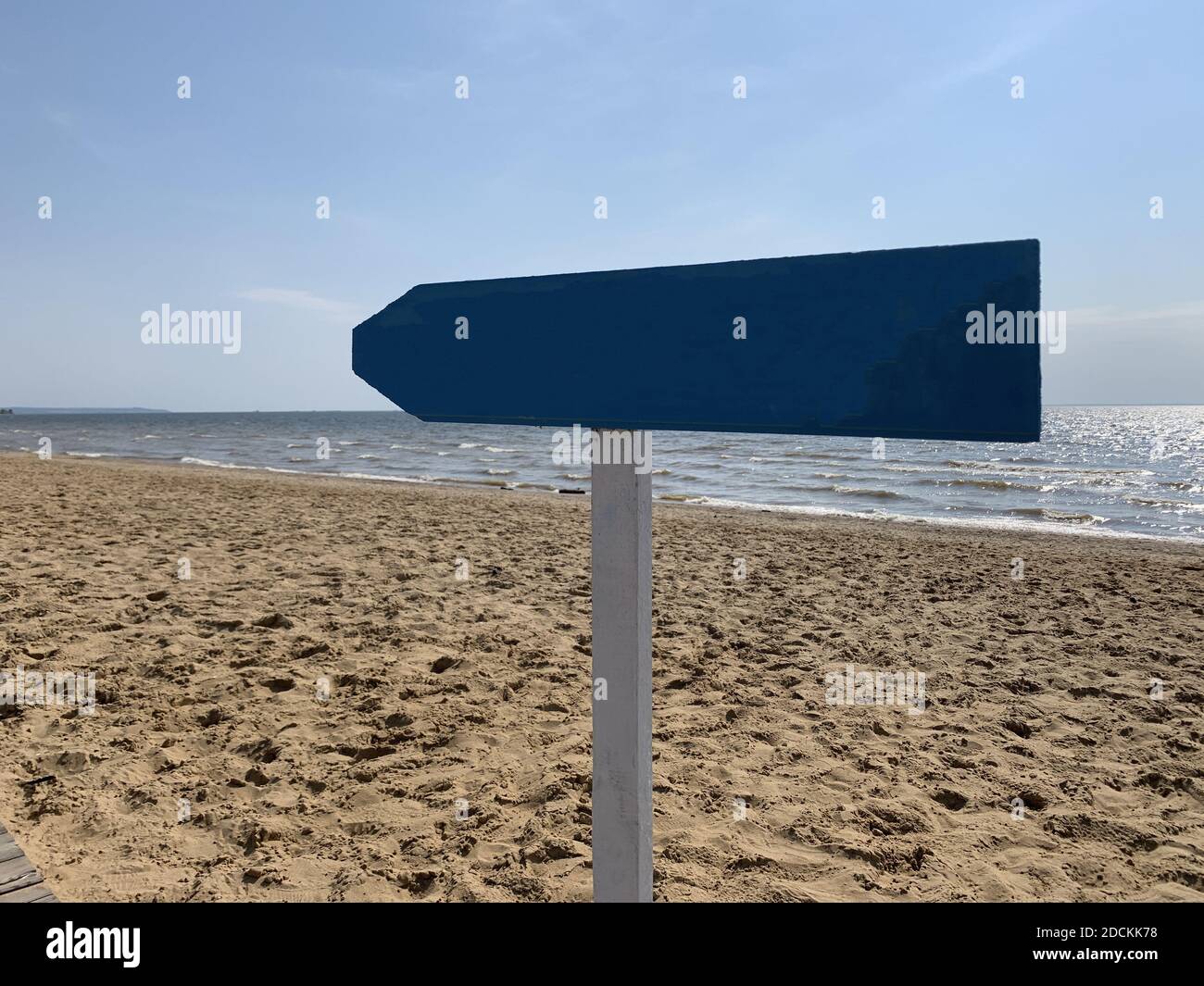 Wooden pointer on the beach. Vertical Stock Photo - Alamy