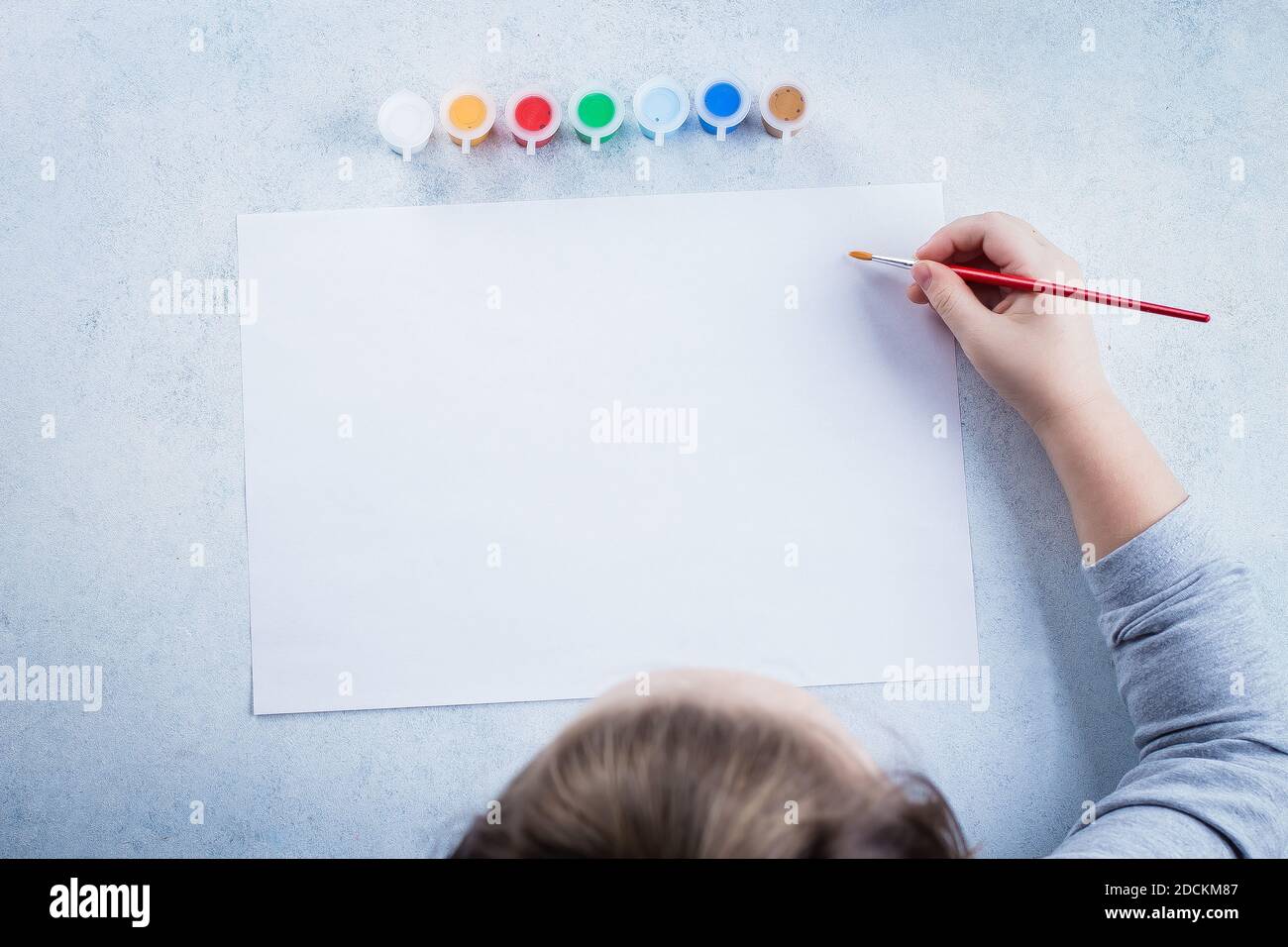 Girl drawing. Little girl is painting with gouache at home. Top view ...