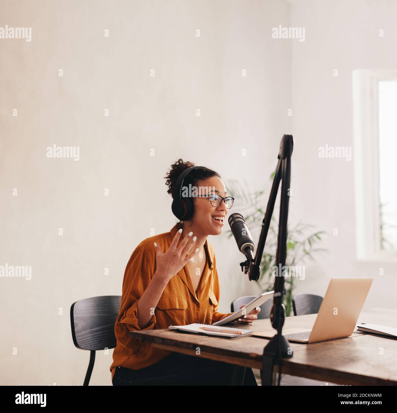 Professional female podcaster making a podcast from home studio. Woman ...