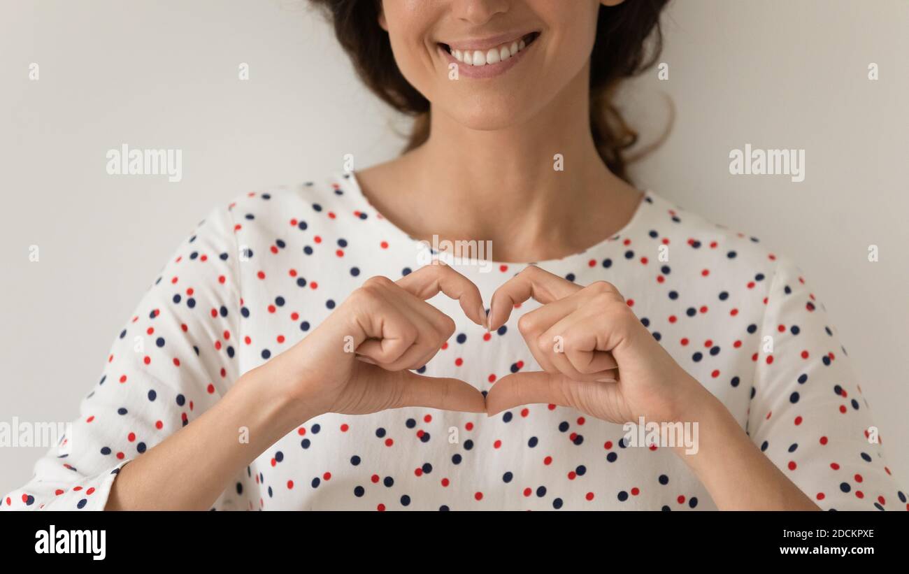 Crop of happy woman show heart hand gesture Stock Photo - Alamy