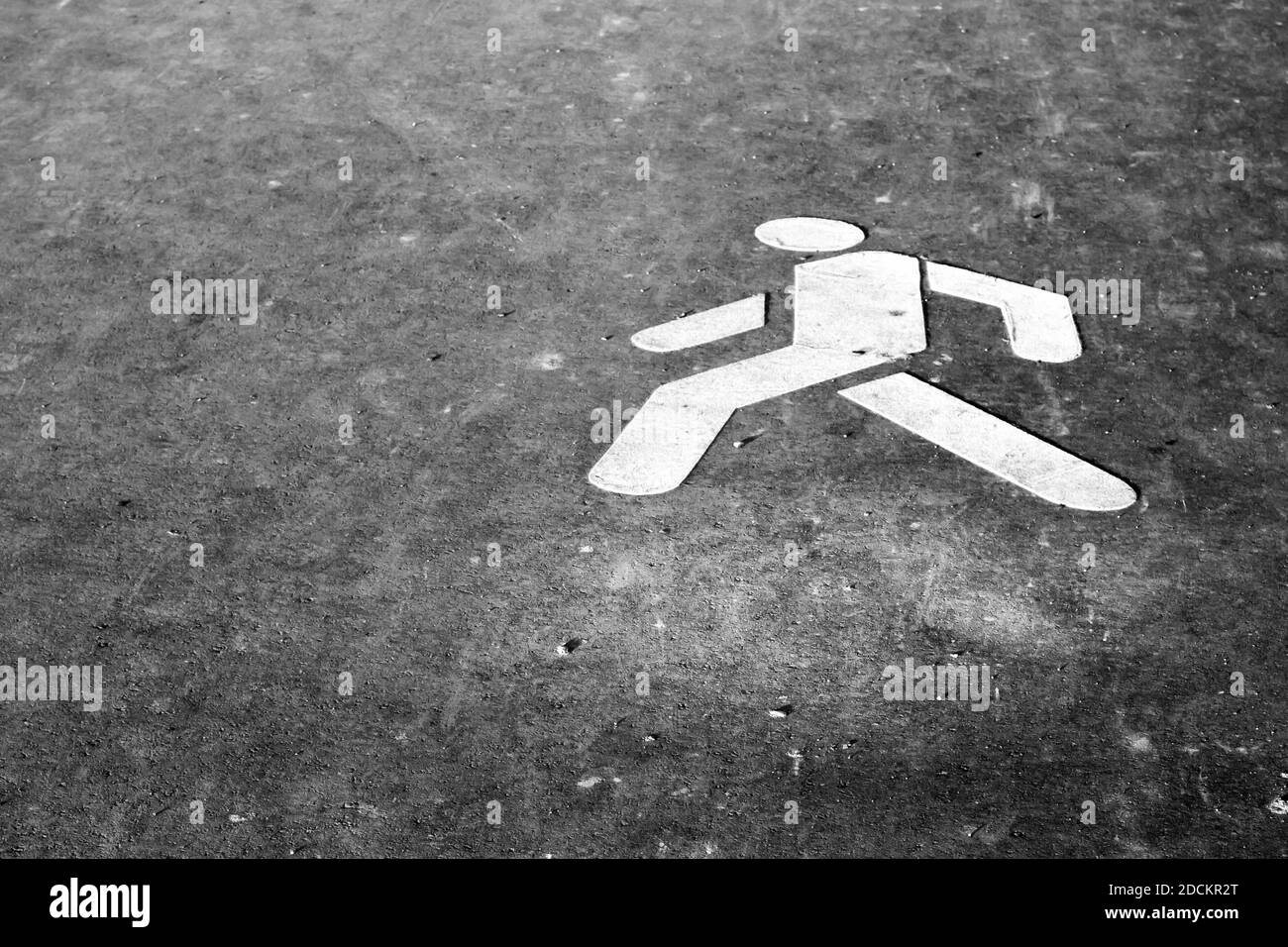 the sign of a pedestrian walkway painted on the pavement, a black-and ...