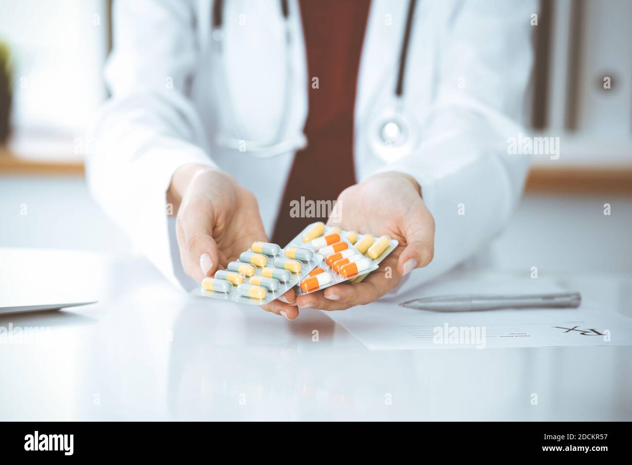 Unknown woman-doctor offering pack of different tablet blisters, close ...