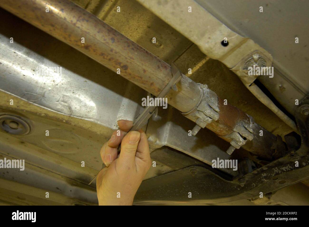 mechanic measures exhaust pipe of a car at the car repair shop Stock ...