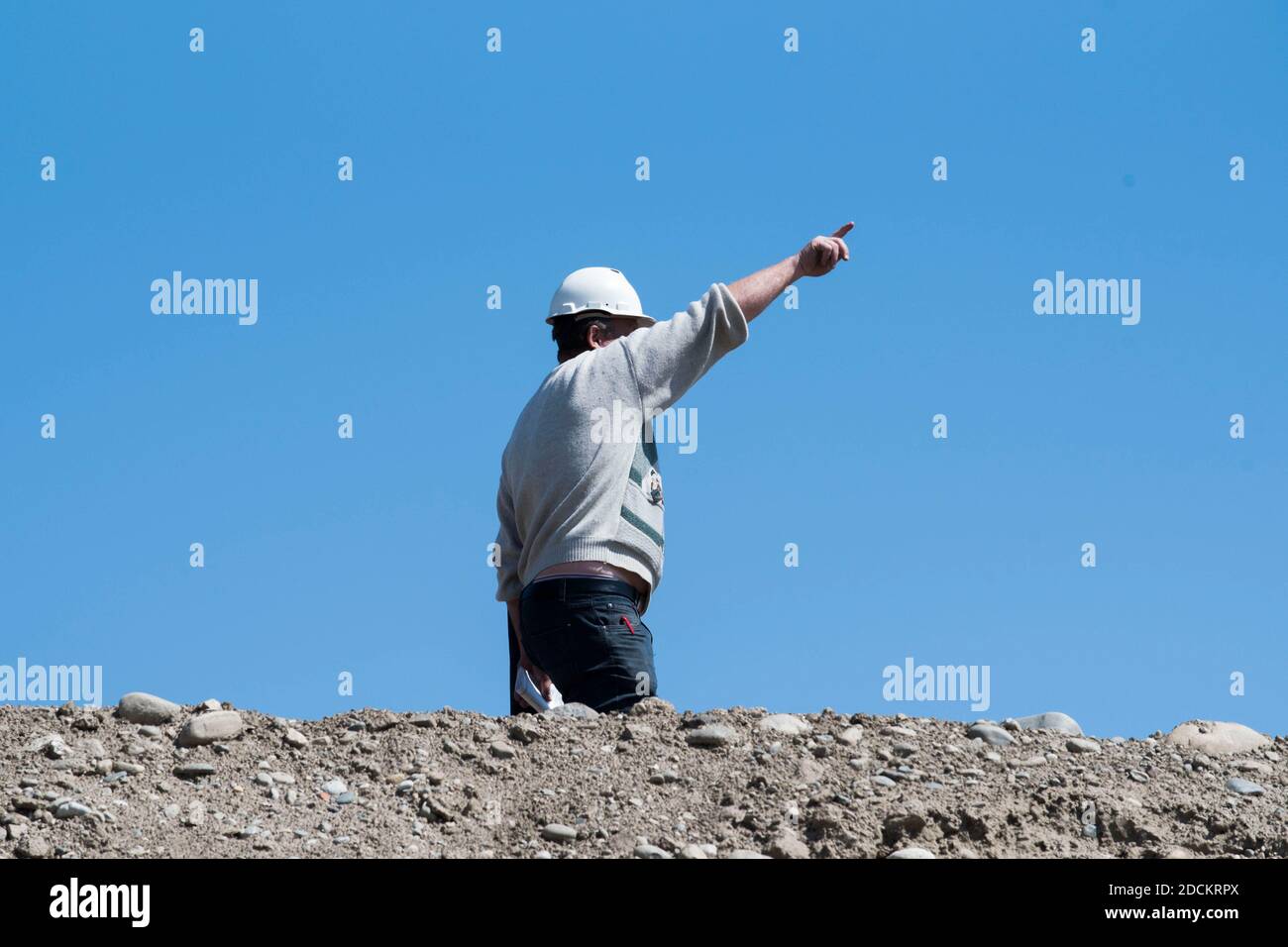 civil engineer pointing his finger to the blue sky at work on ...