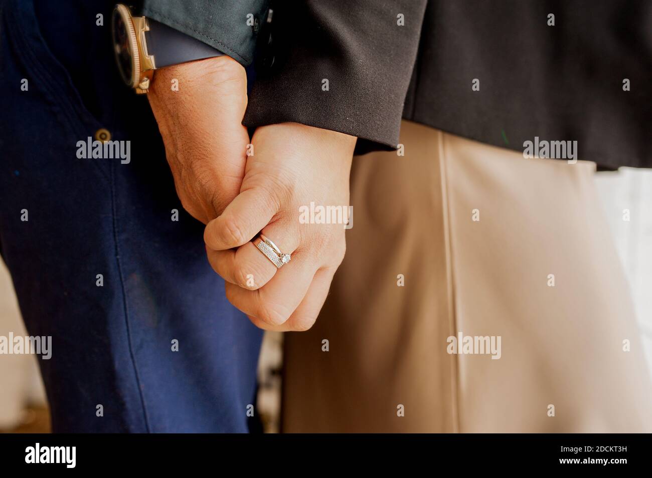 heterosexual couple without faces holding hands close-up, on the womans ...