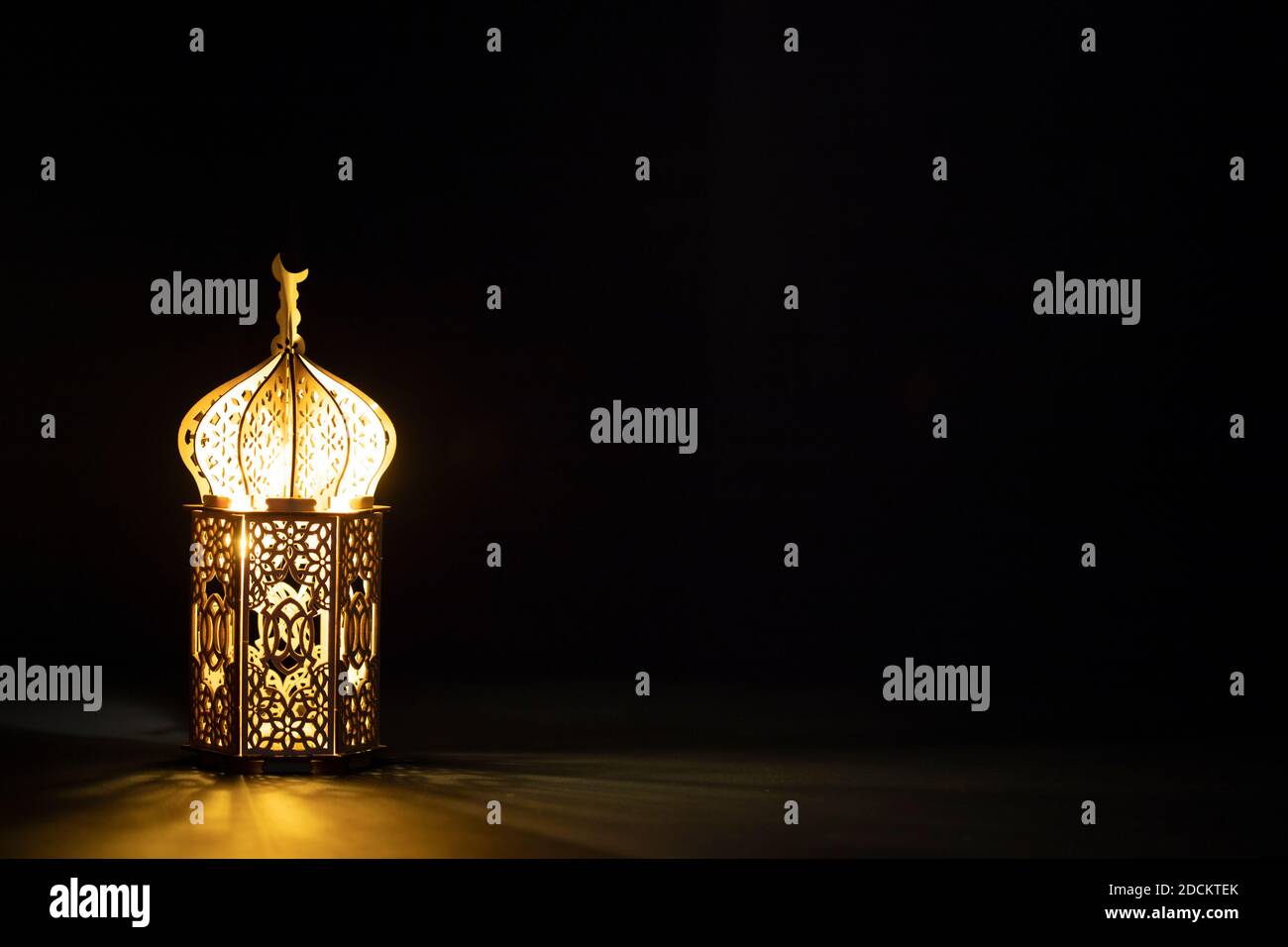 Ornamental Arabic lantern with burning candle glowing at night and ...