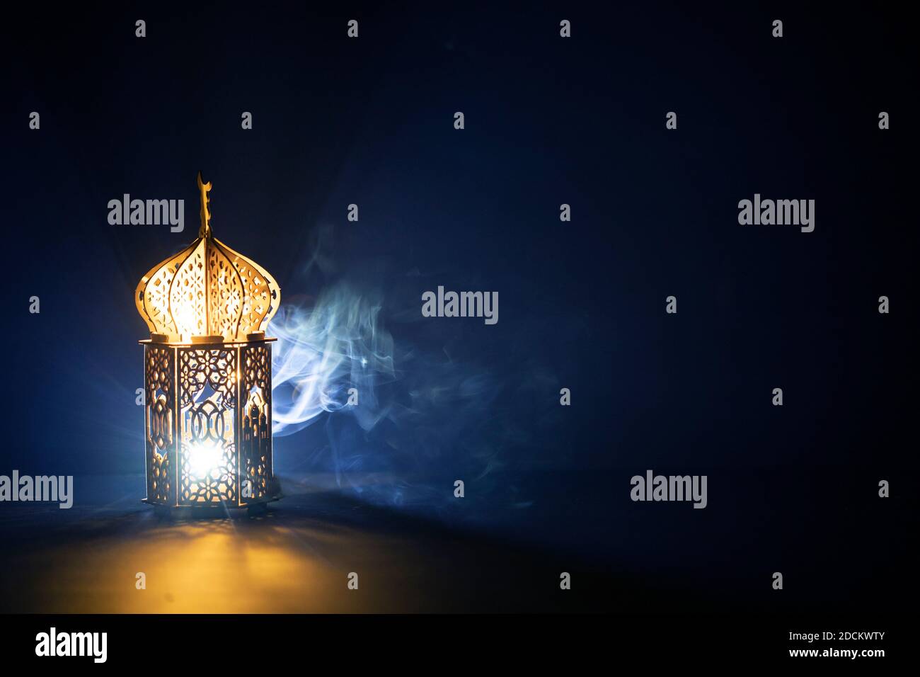 Ornamental Arabic lantern with burning candle glowing at night and ...