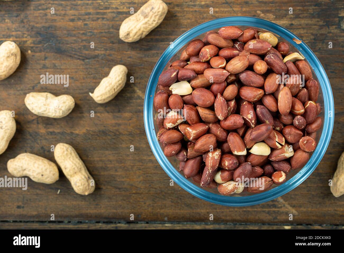 Peanuts in their husks in a glass bowl and peanuts in their skins are ...