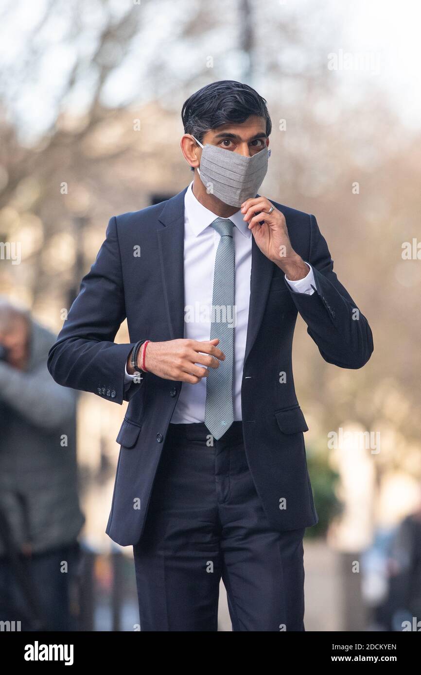 Chancellor of the Exchequer Rishi Sunak puts on a face mask after being ...