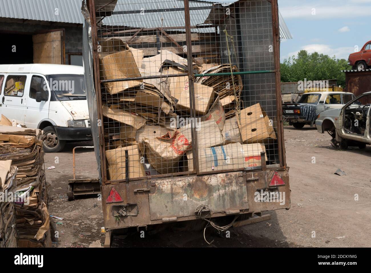 A trailer with cardboard boxes prepared for recycling stands in a ...