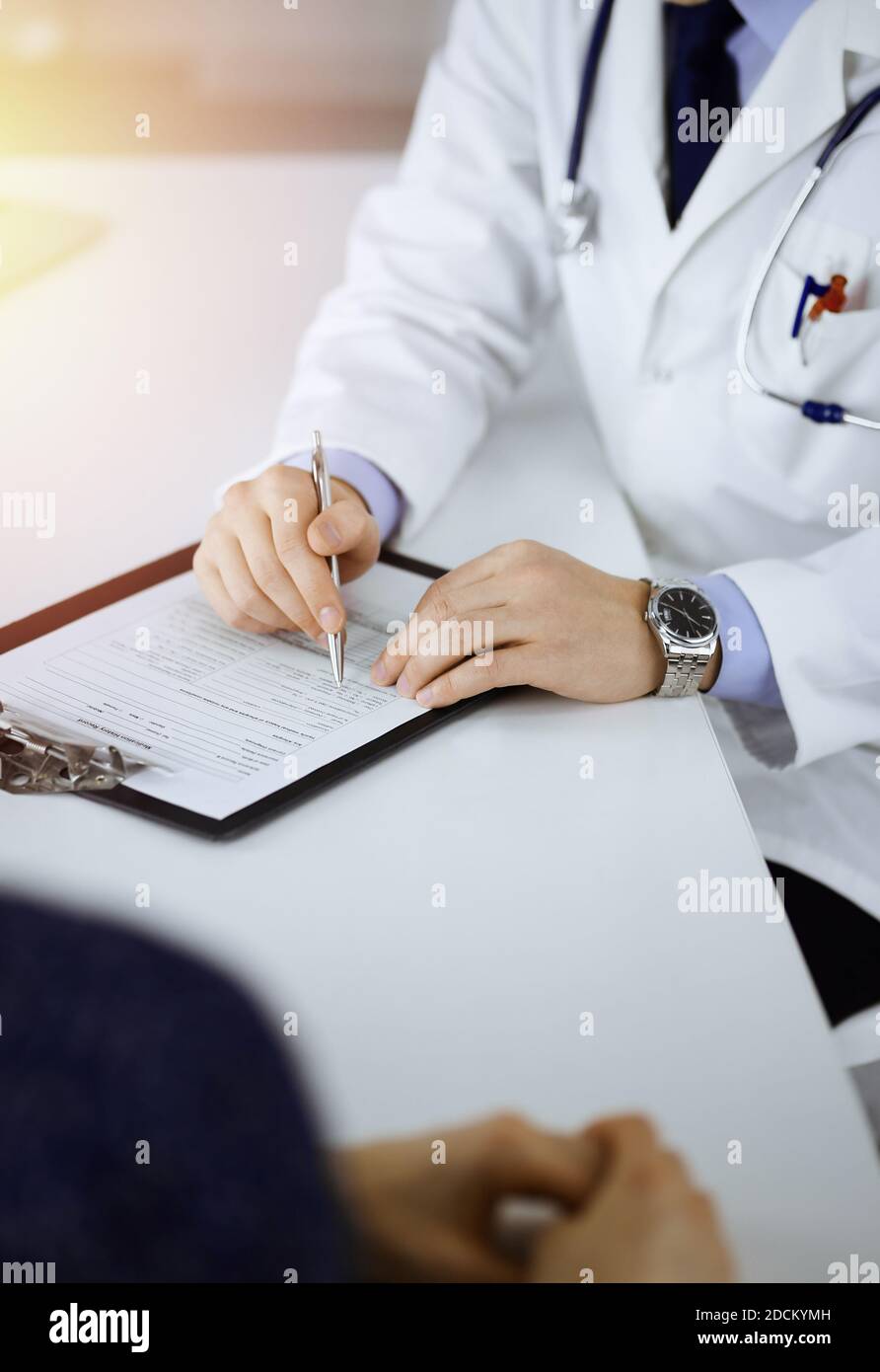 A doctor is writing a medical prescription for his patient, while ...